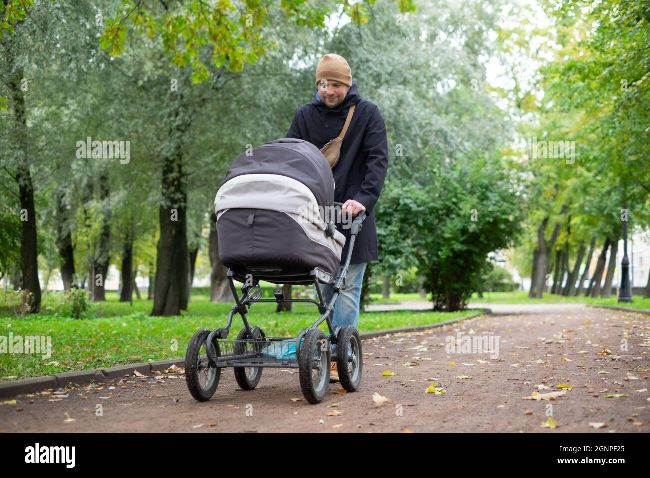 Happy young father with pram during the walk in nature Stock Photo - Alamy