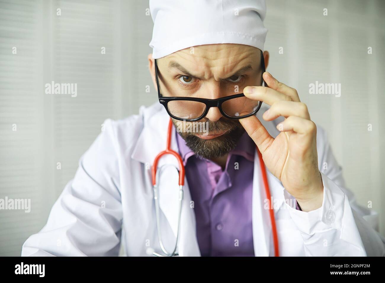 A cross-eyed bearded man is looking into the frame. Eye disease. The ...