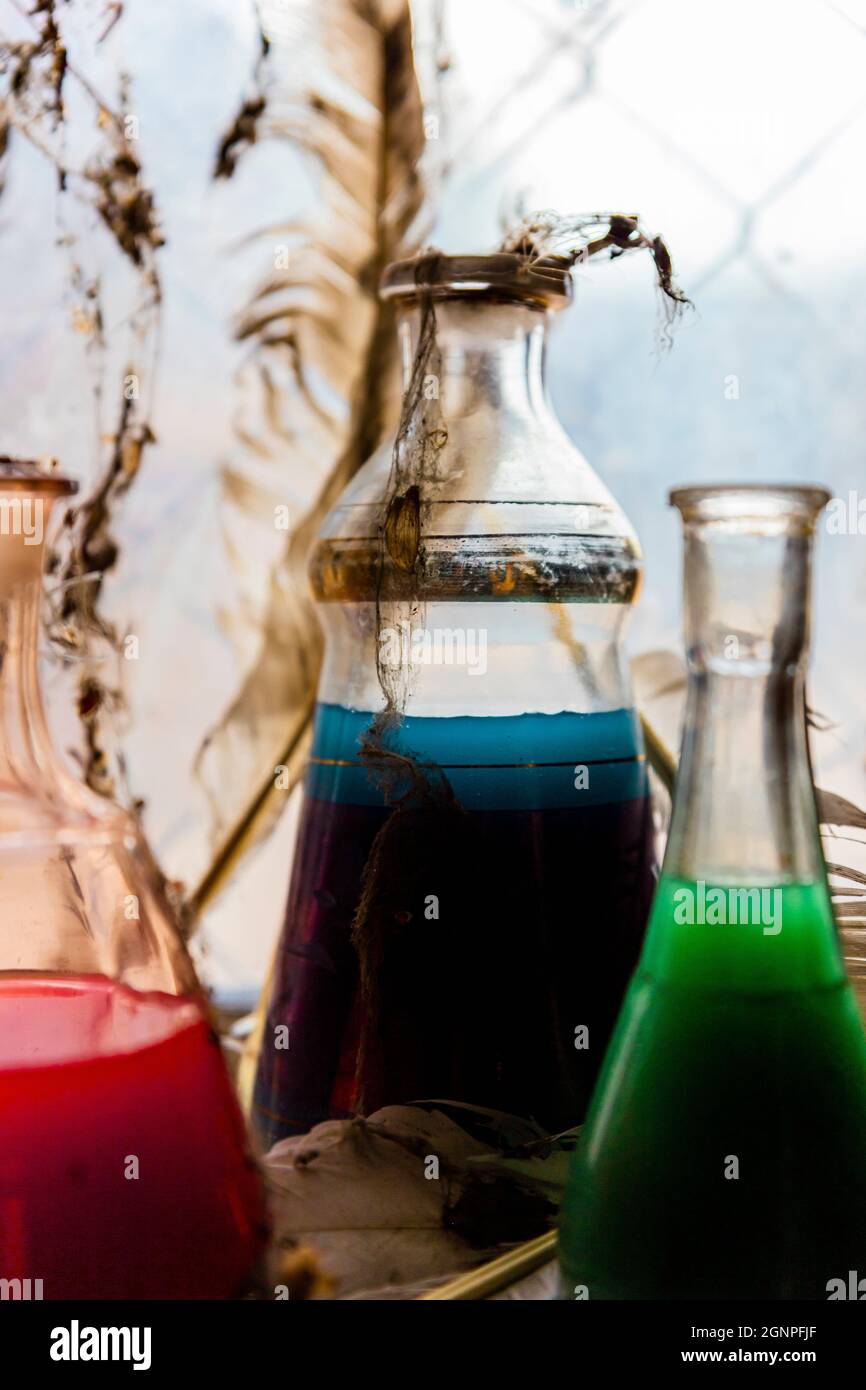 Magic potions in bottles near old rustic window with backlight ...