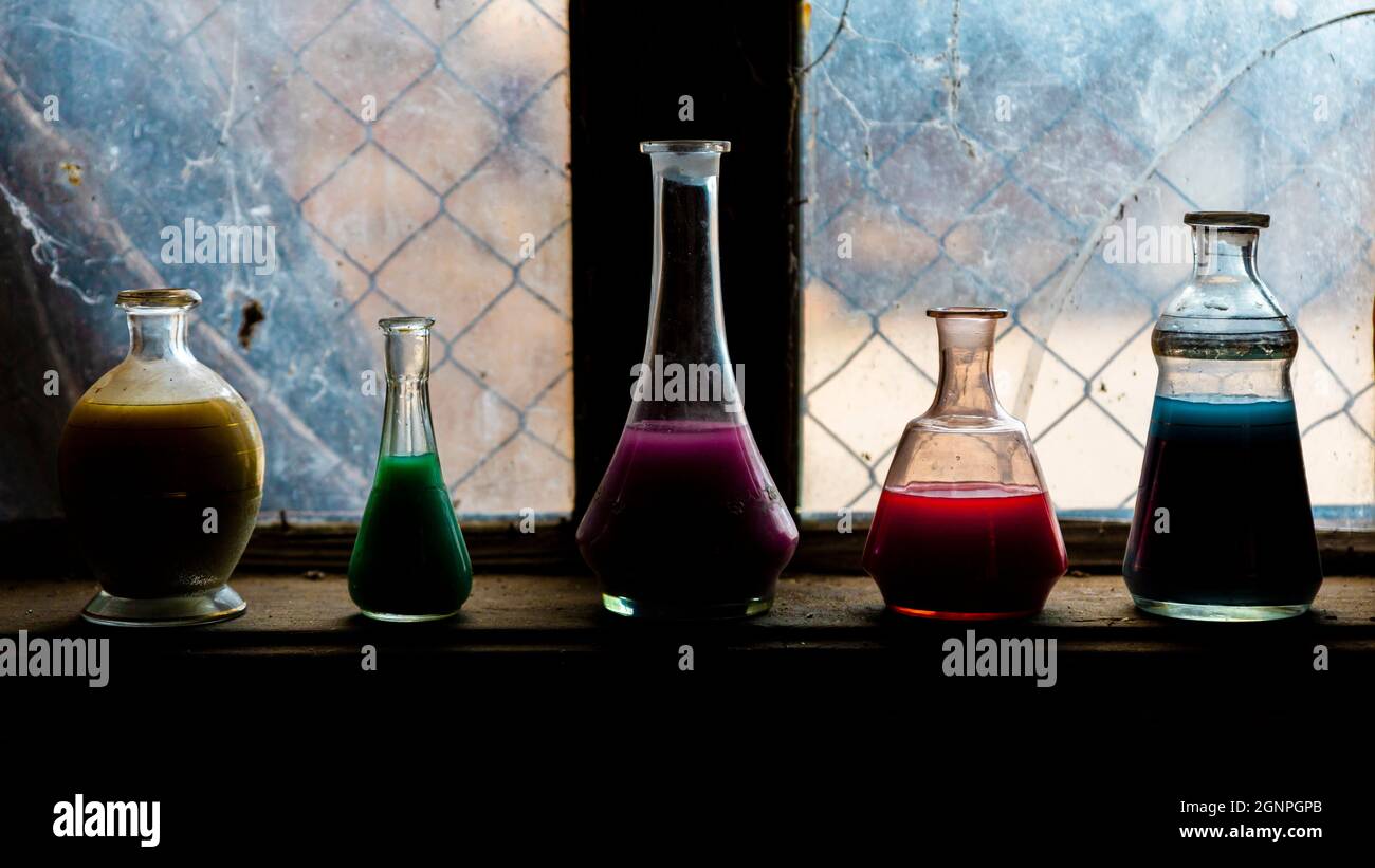 Magic potions in bottles near old rustic window with backlight ...