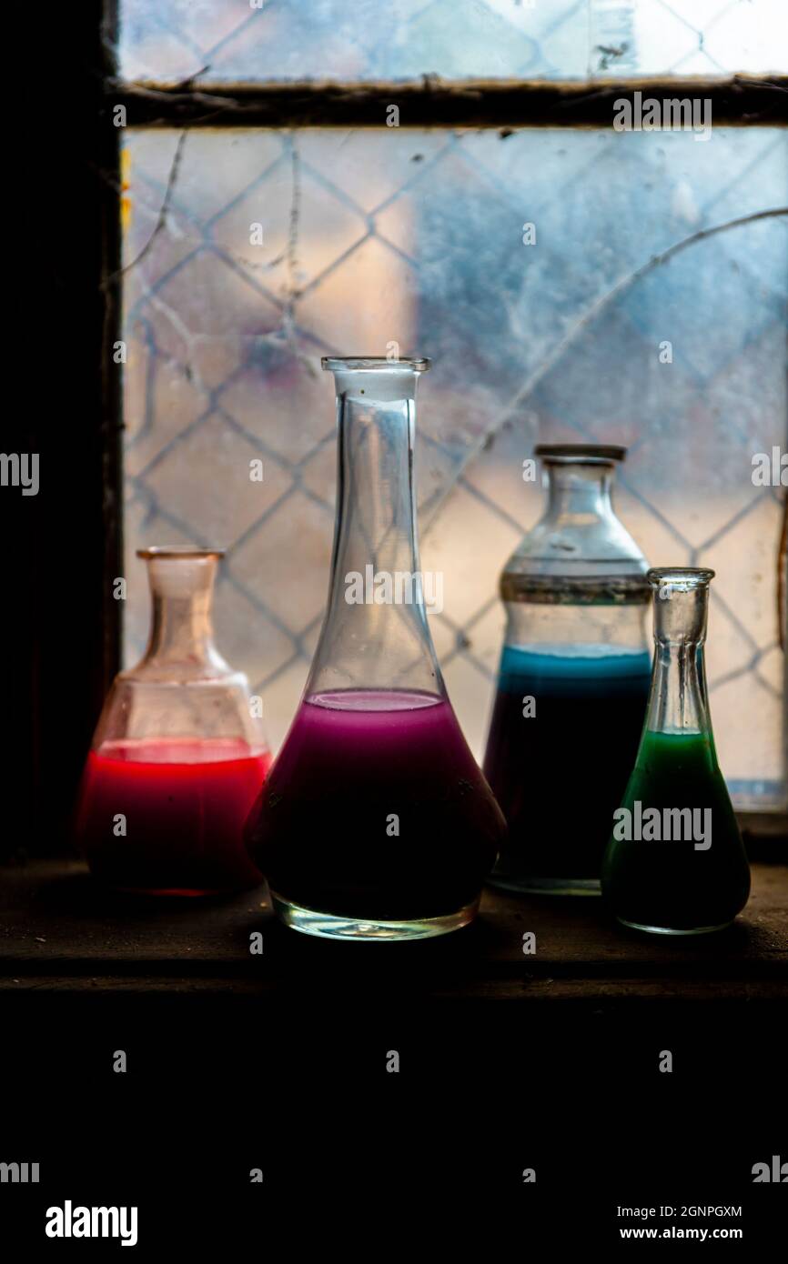 Magic potions in bottles near old rustic window with backlight ...