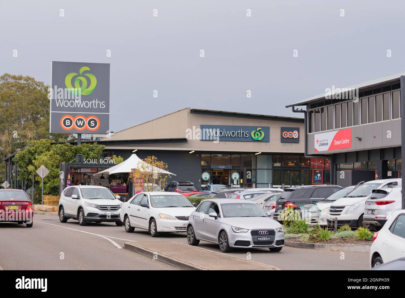 Cars queued and parked outside a Woolworths Supermarket at Harris Park ...