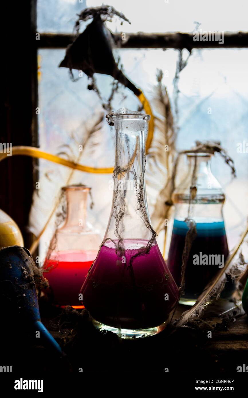 Magic potions in bottles near old rustic window with backlight ...