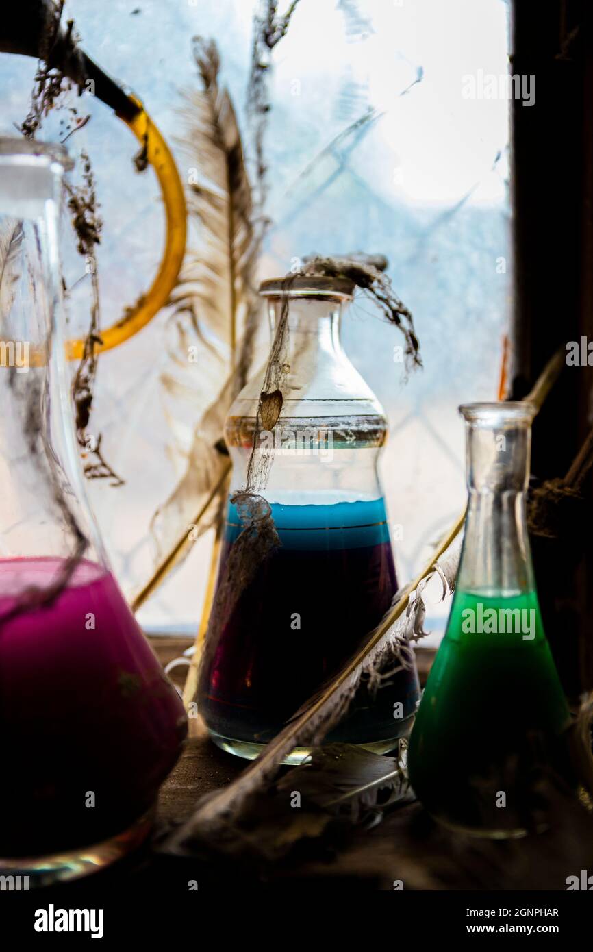 Magic potions in bottles near old rustic window with backlight ...