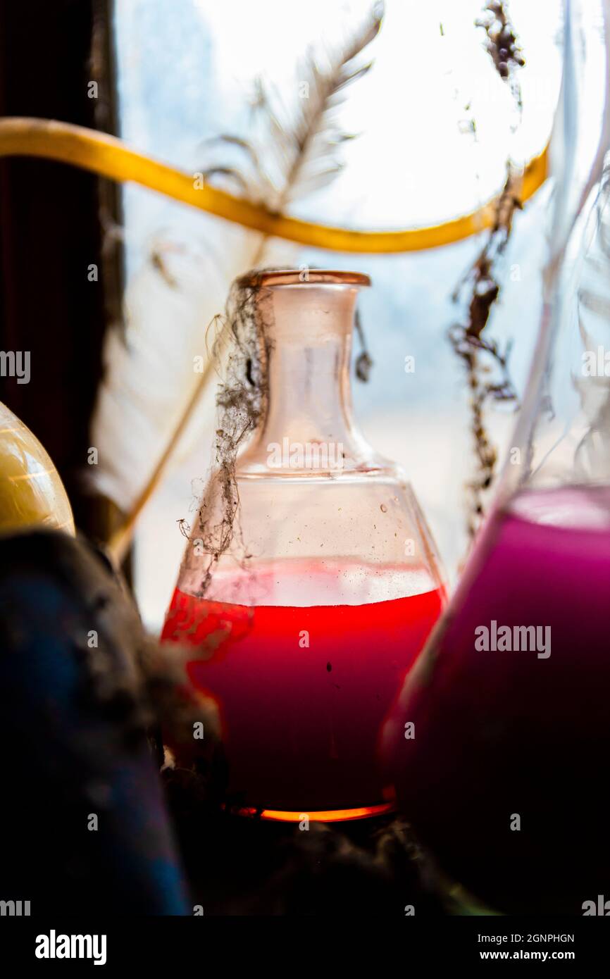 Magic potions in bottles near old rustic window with backlight ...
