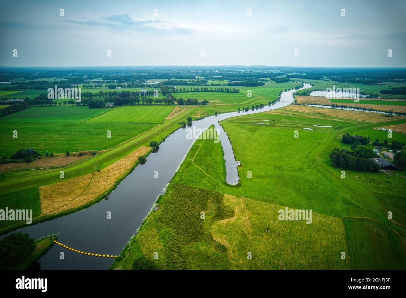 Drone view of the winding river Vecht, green grass, blue water, yellow ...