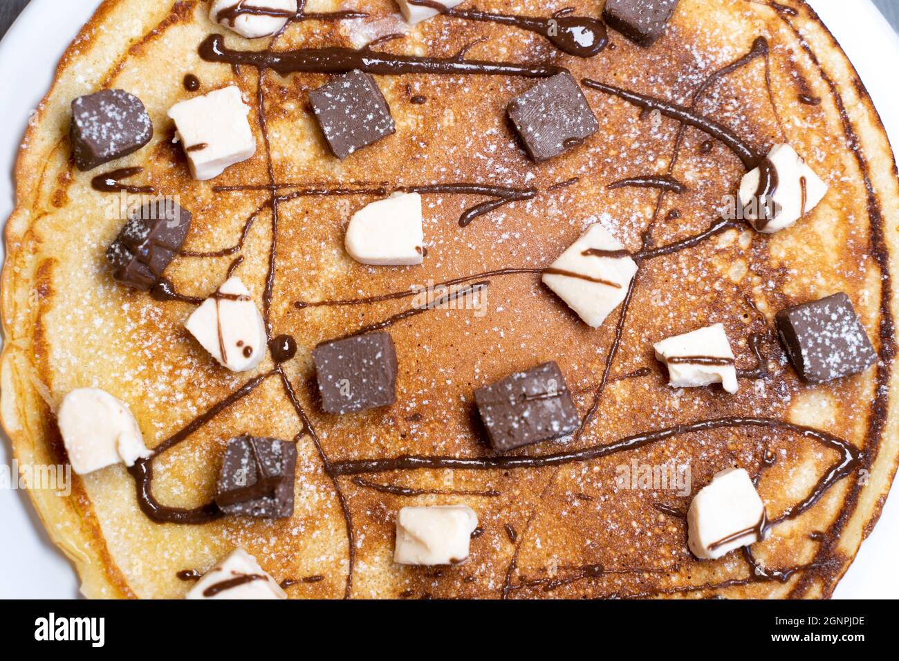 Aerial photo of a pancake decorated with dark and white chocolate ...