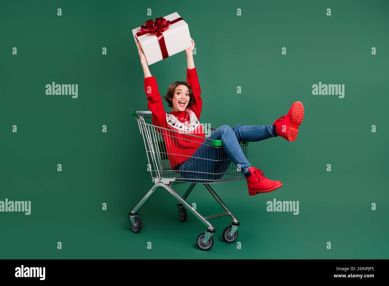 Portrait of attractive cheerful girl riding cart having fun carrying ...