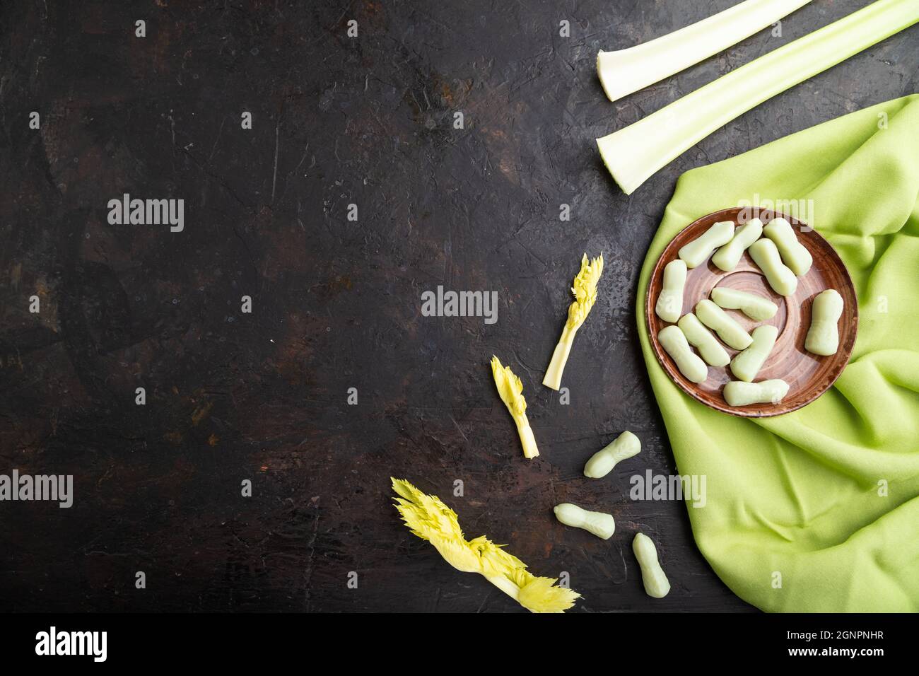 Jelly celery candies on black concrete background and green linen ...