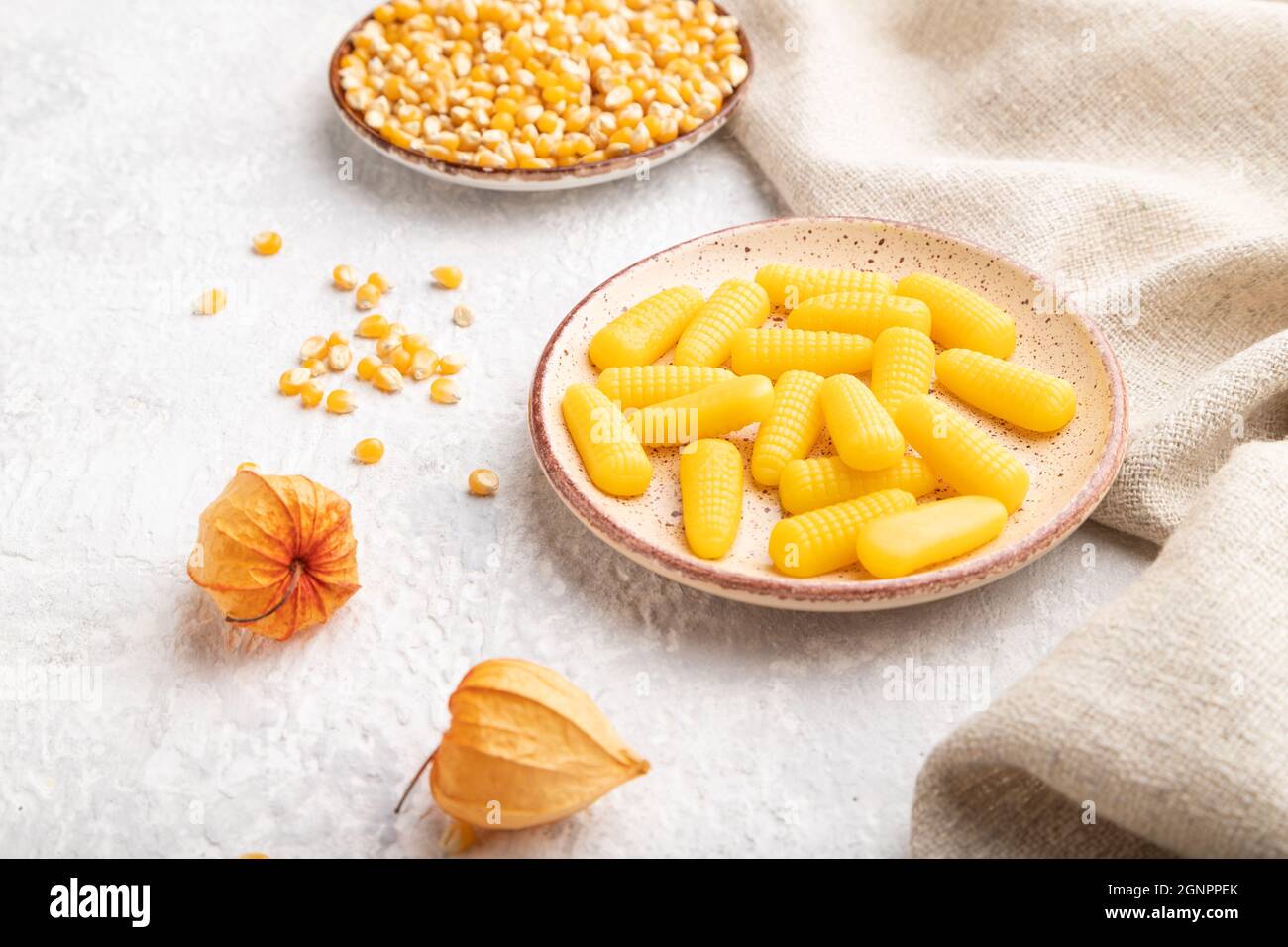 Jelly corn candies on gray concrete background and linen textile. side ...