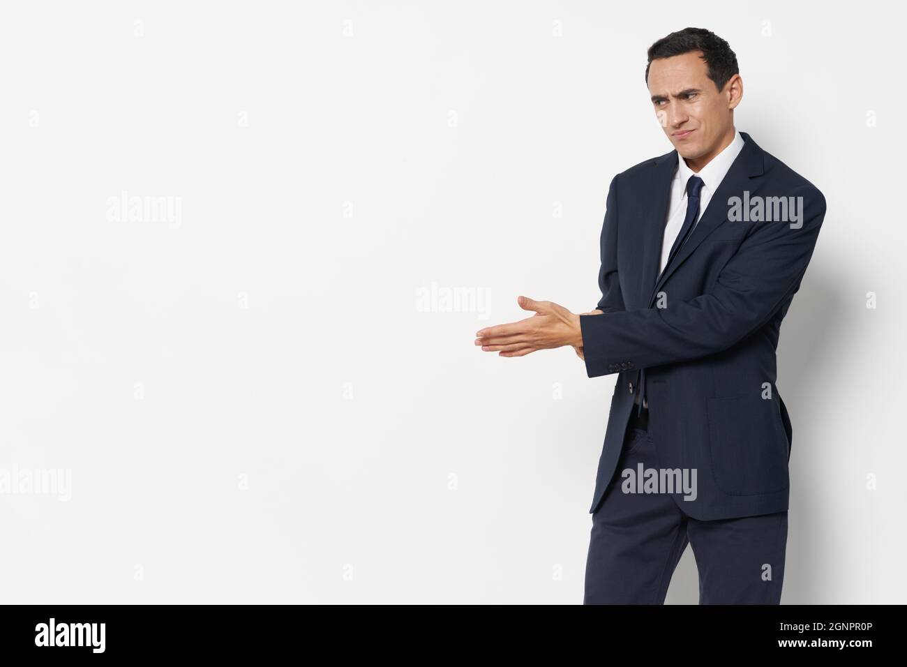 business man in a suit on a light background shows his hand to the side ...