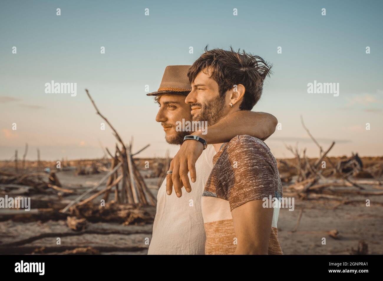 Two friends hug each other looking sunset on the beach. Friendship and ...