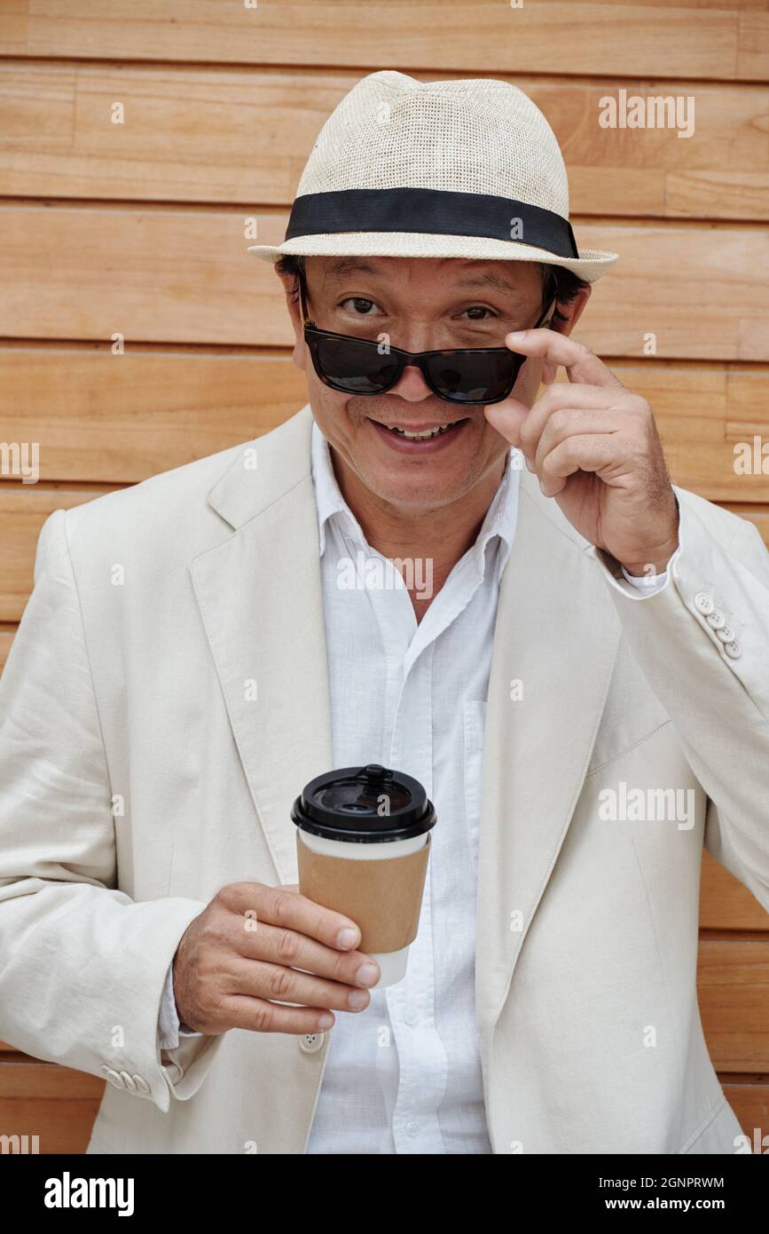 Portrait Of Happy Mature Asian Man In White Jacket And Stra Hat Taking