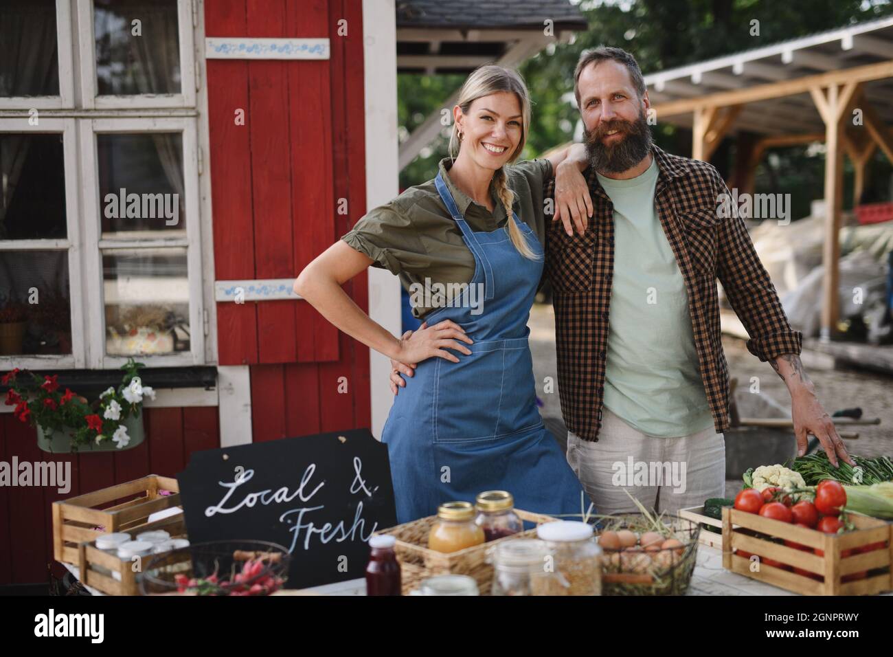 Mature couple farmers selling homegrown products at community farmers ...