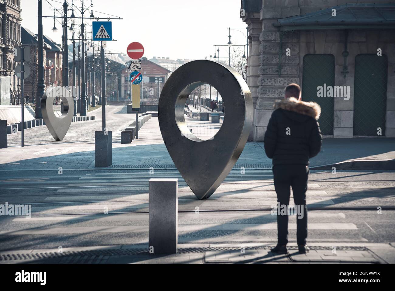 Man standing on a city street and looking at location marker Stock ...