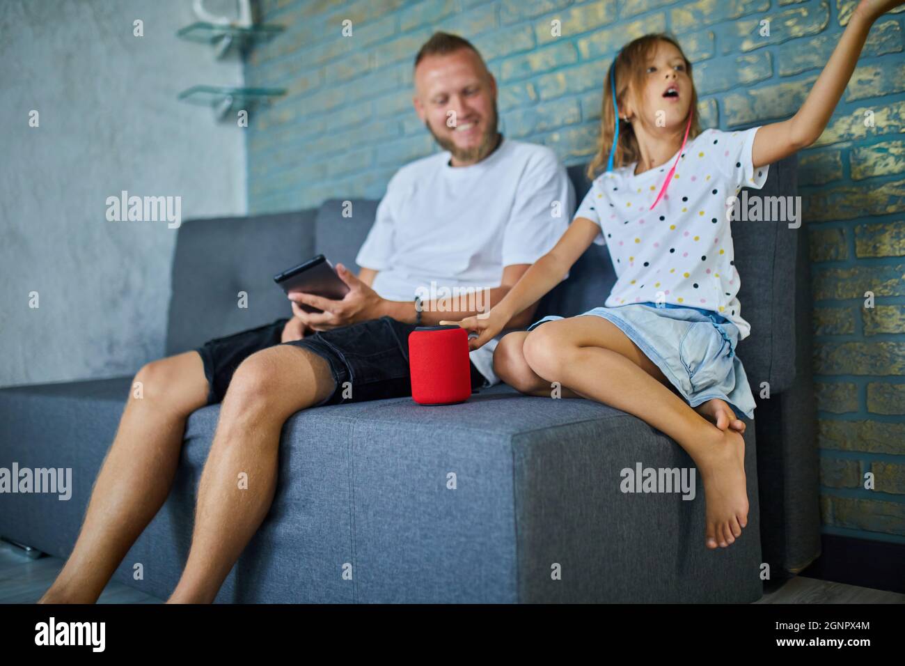 Father and daughter testing talking smart wireless speaker, controlling ...
