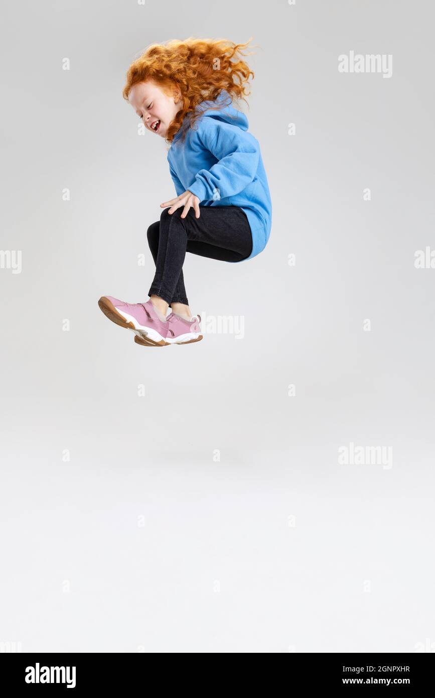 Portrait of little Caucasian girl, child jumping and posing isolated ...