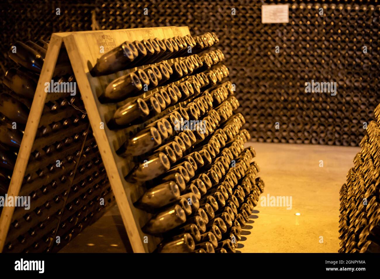 Walking in deep and long undergrounds caves with dusty bottles on racks ...