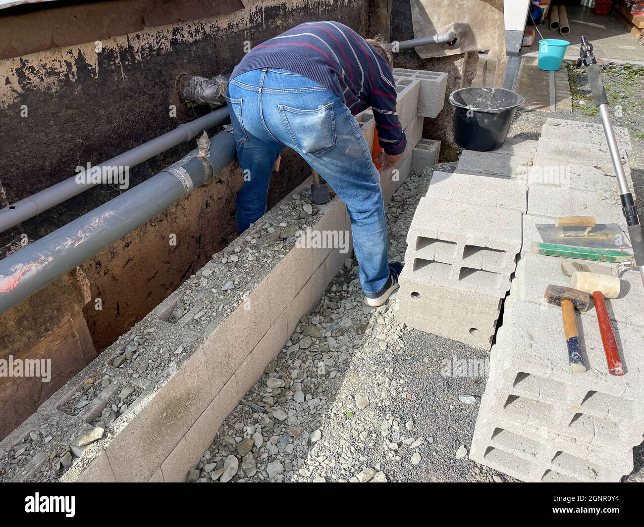 Construction worker sets new concrete block wall on the house Stock ...