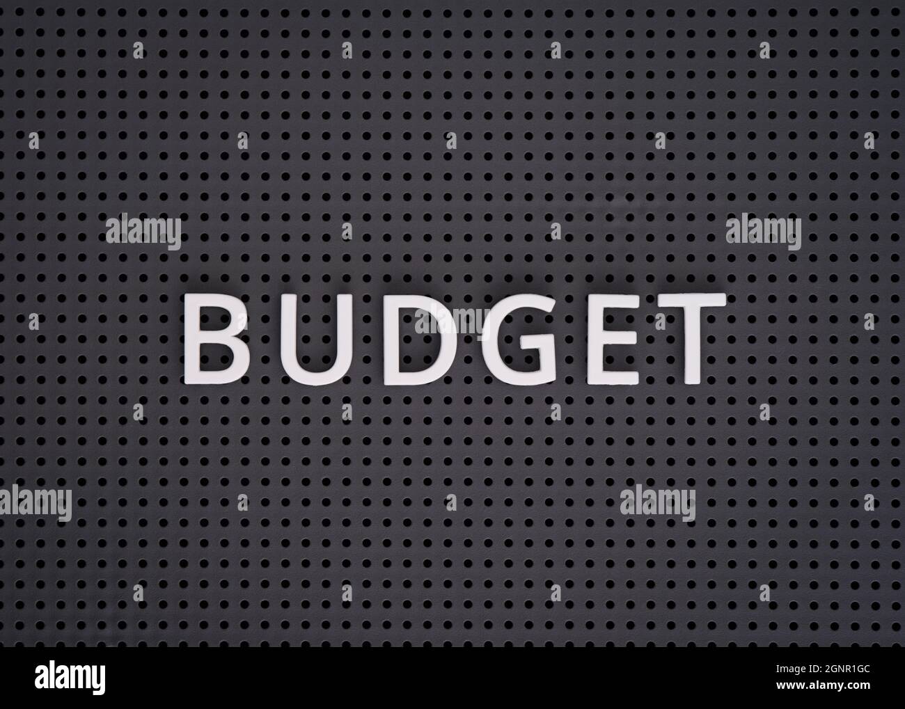 Word Budget spelled out with white letters on a gray pegboard Stock ...