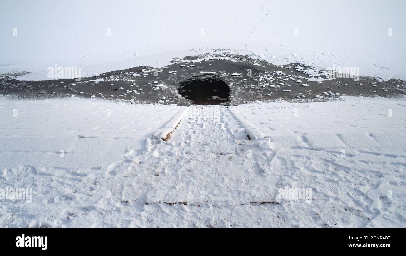 High angle view of water hole in frozen lake Stock Photo - Alamy