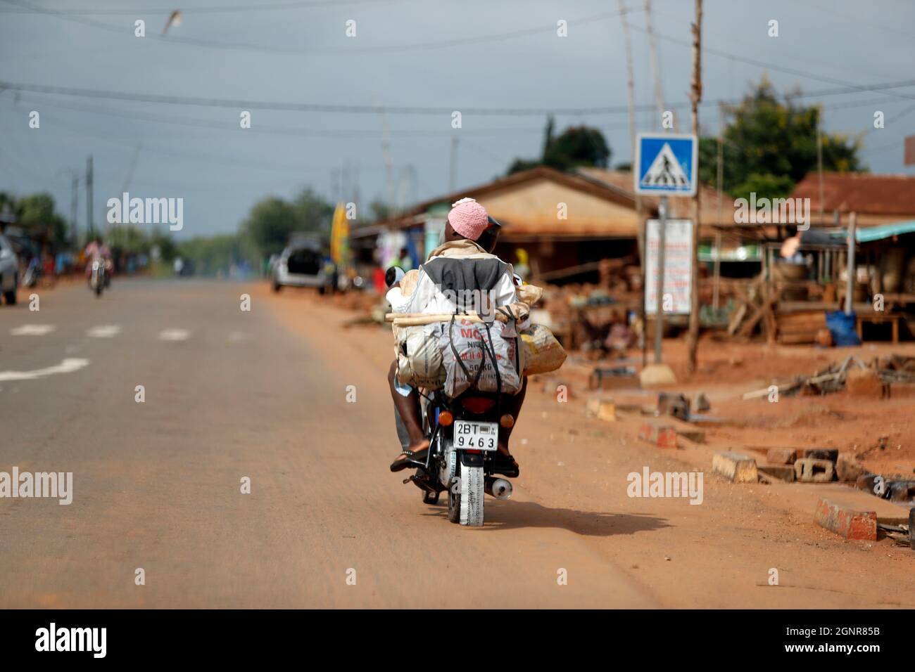 Street scene with african people riding a motorcycle. Benin Stock Photo ...