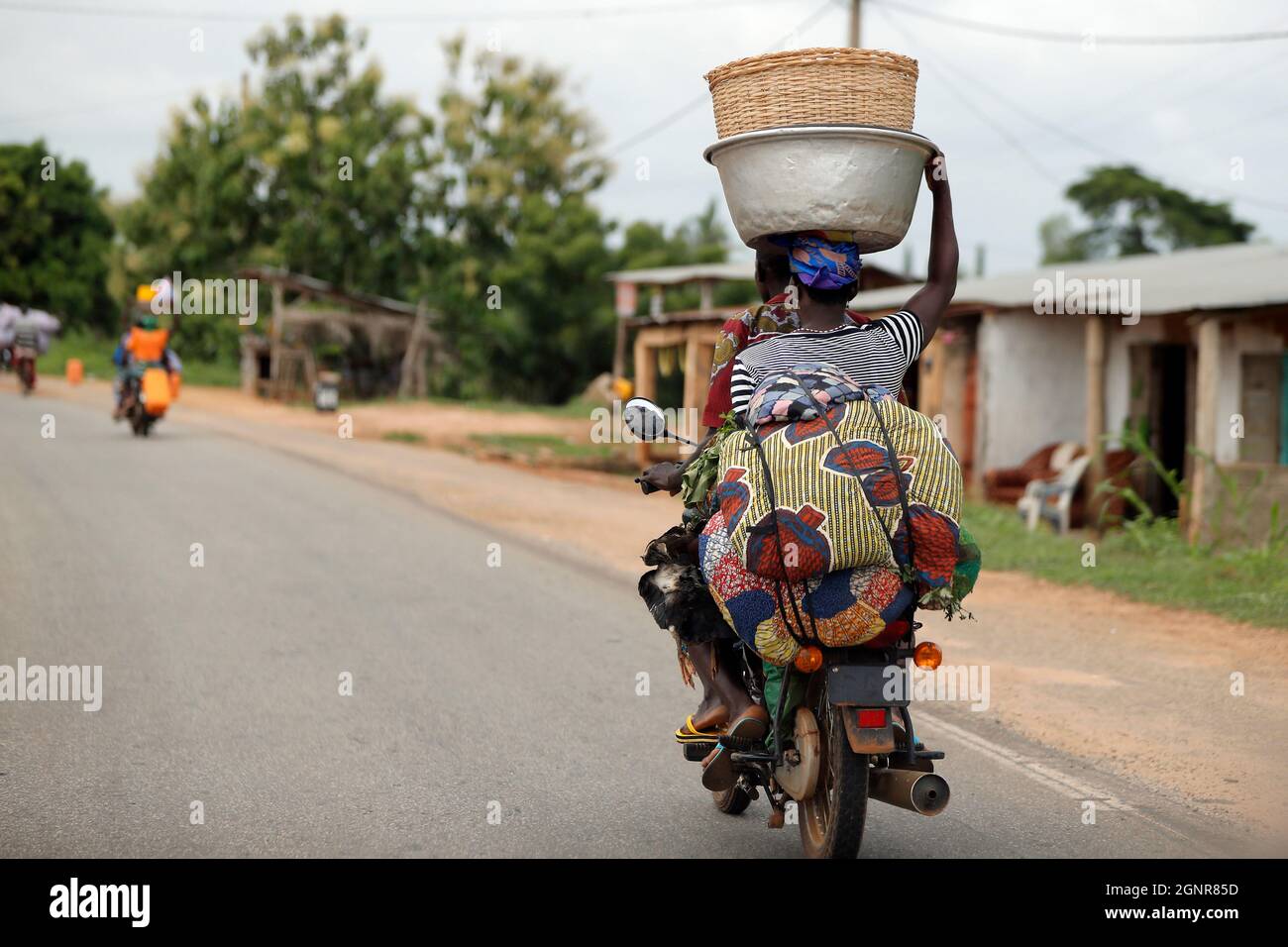 Street scene with african people riding a motorcycle. Benin Stock Photo ...