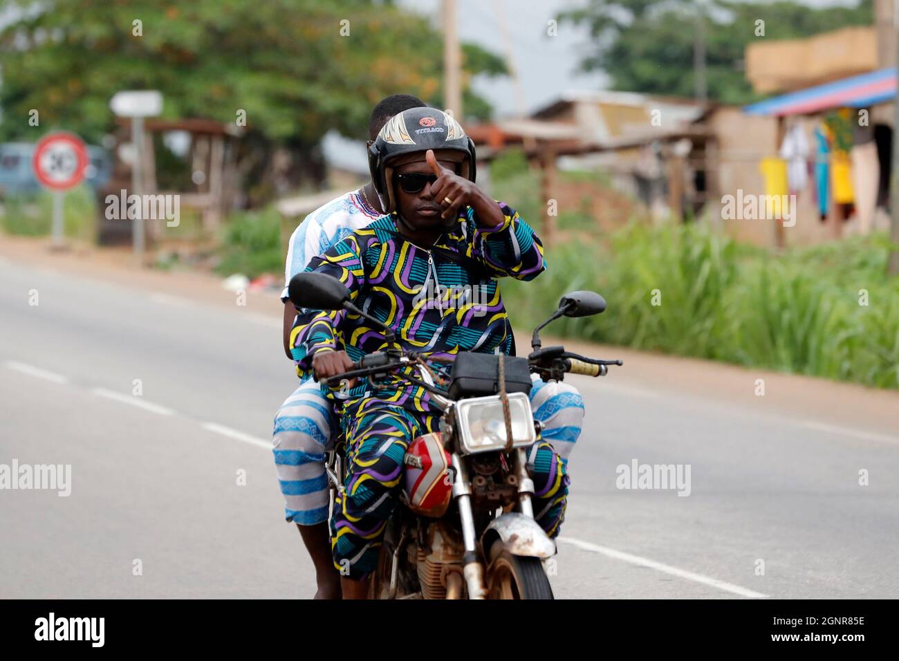 Street scene with african people riding a motorcycle. Benin Stock Photo ...