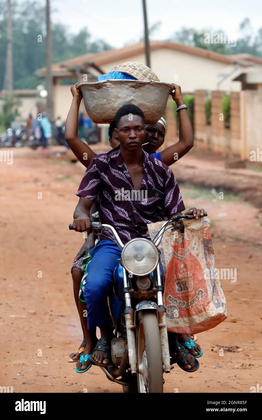 Street scene with african people riding a motorcycle. Benin Stock Photo ...