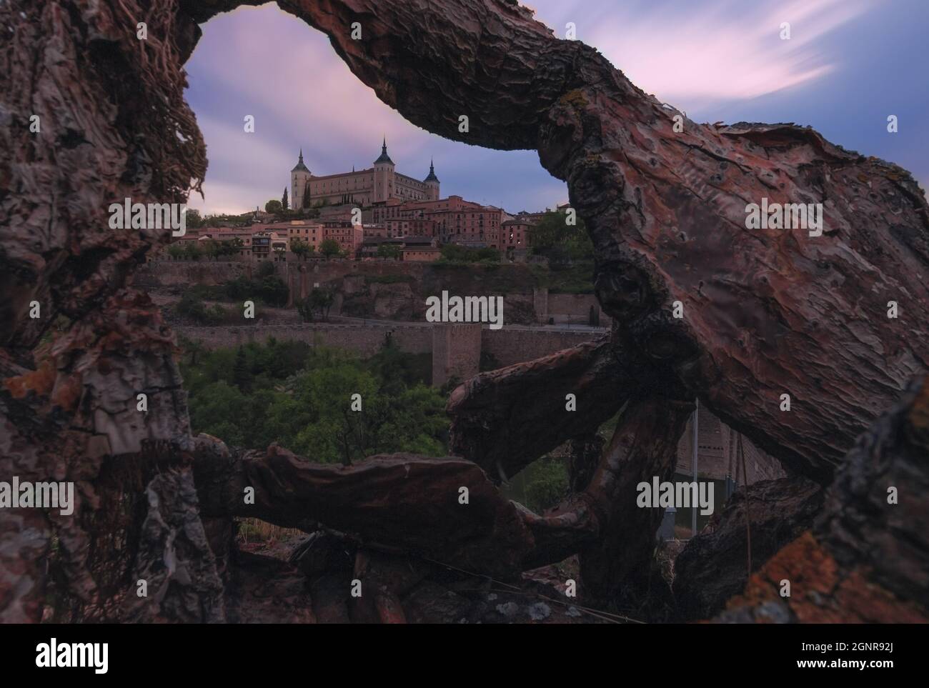 Beautiful view of Alcazar de Toledo castle through the rock under a ...