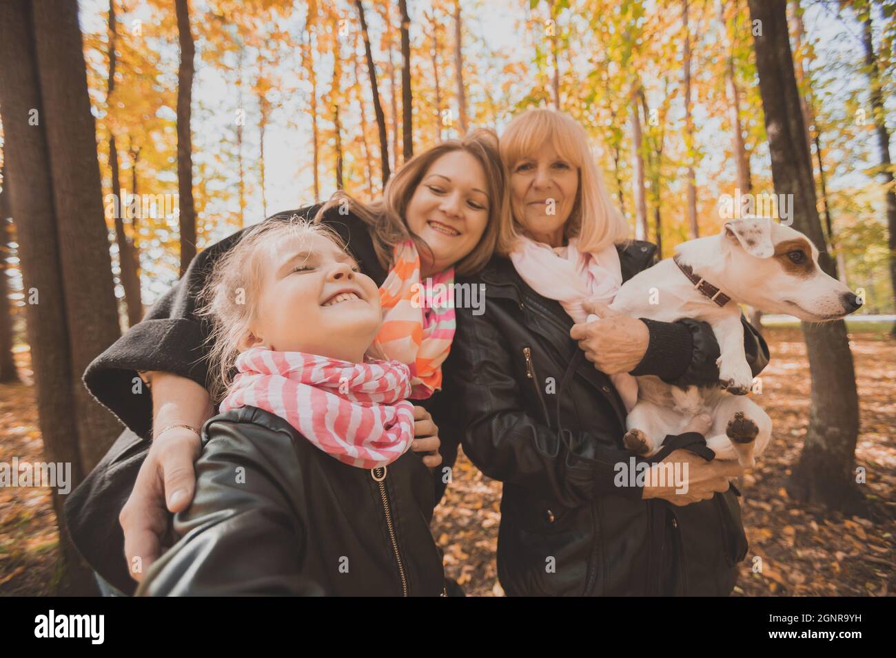 Three generations of women and dog feel fun look at camera posing for ...