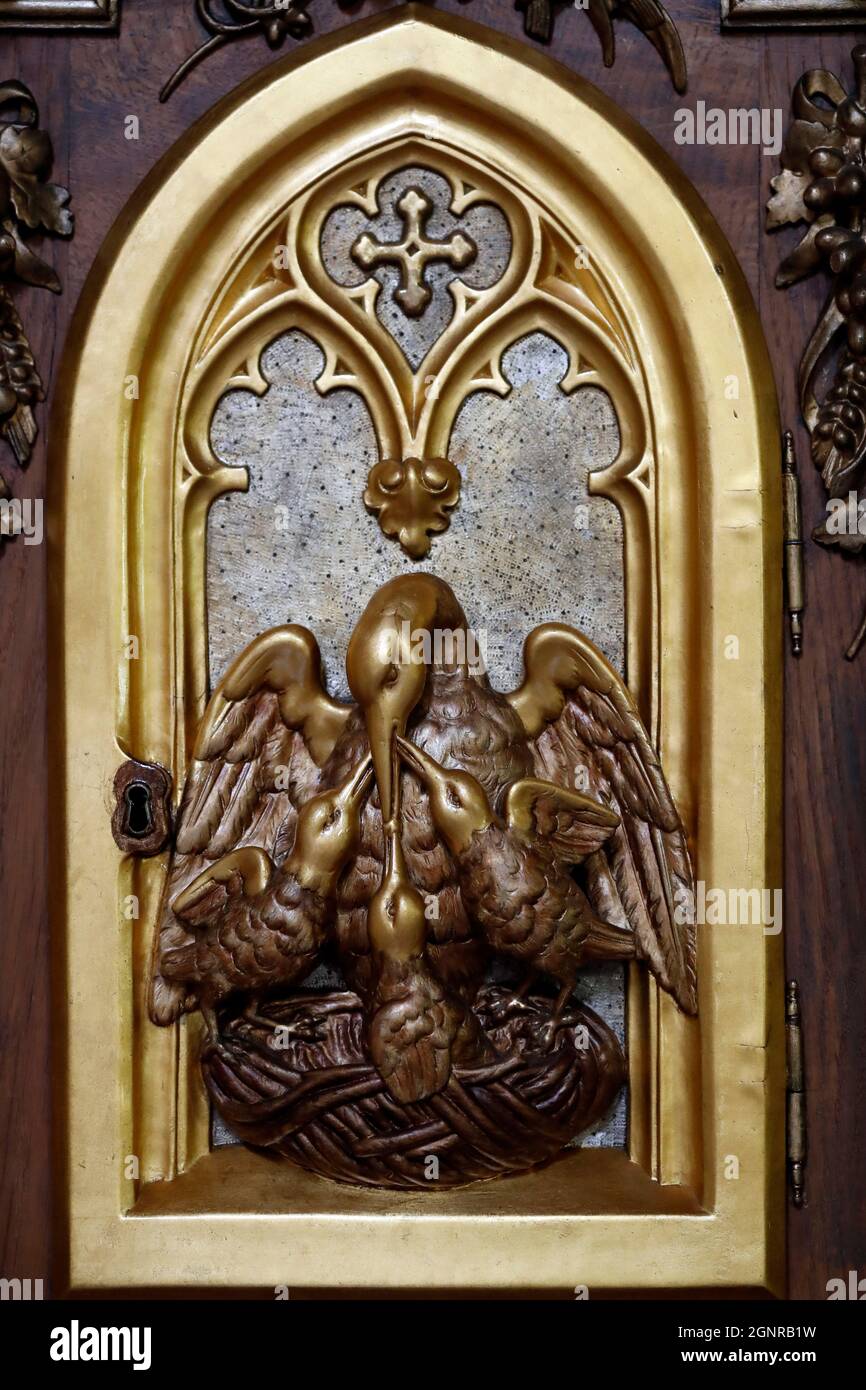 Tabernacle door. Mother pelican feeding her little baby pelicans ...