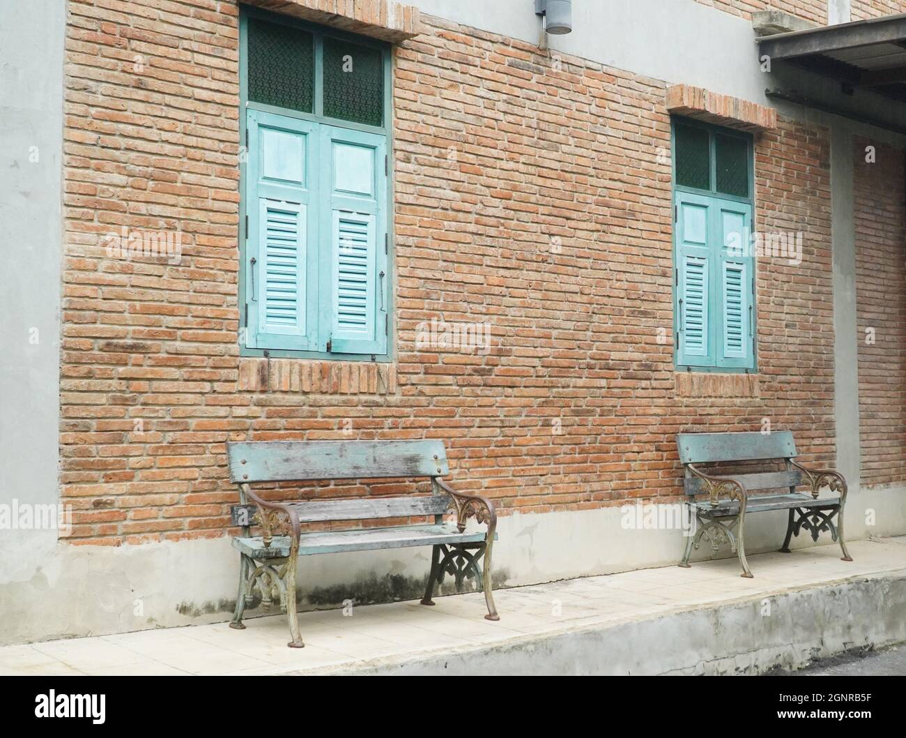 Brick building with blue wooden shuttered windows and benches Stock ...