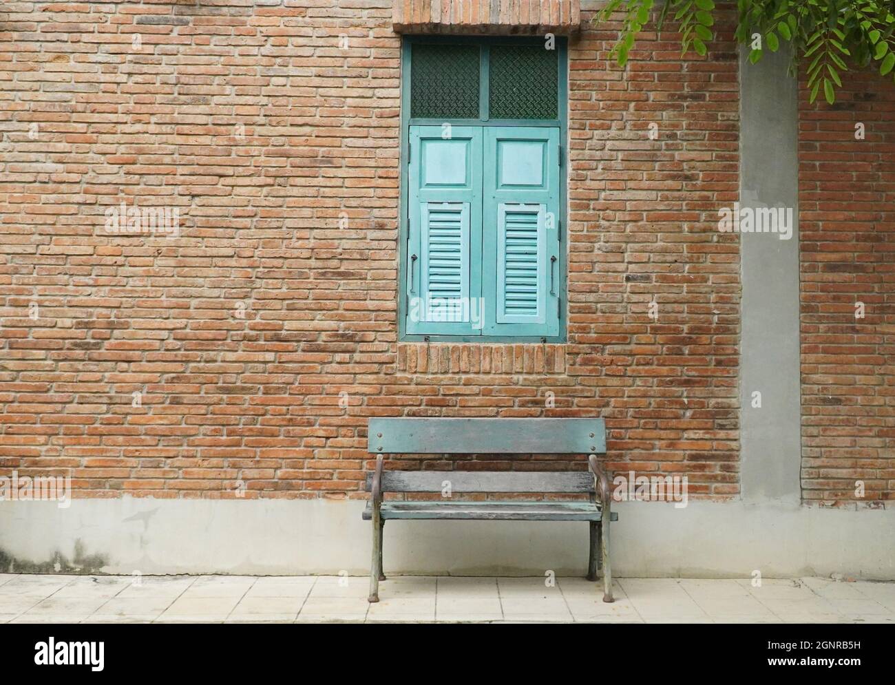 Brick building with blue wooden shuttered window and bench Stock Photo ...