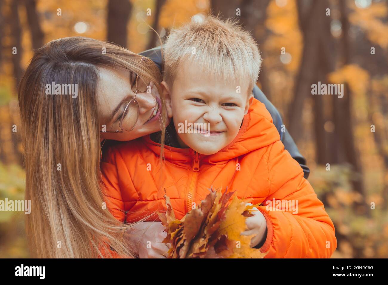 Mother hugging her child during walk in autumn park. Fall season and ...