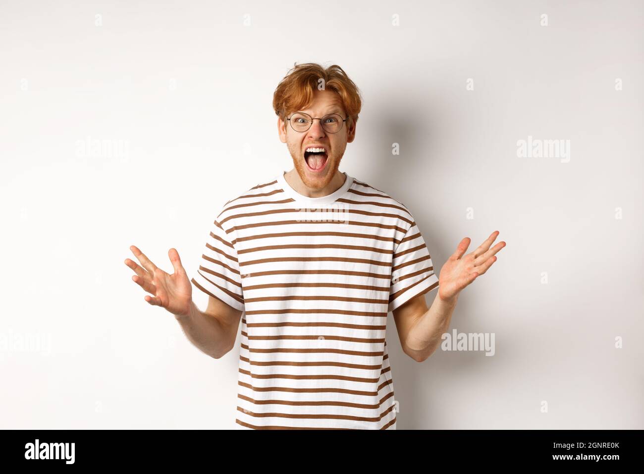 Frustrated man with red hair shaking hands and yelling at camera ...