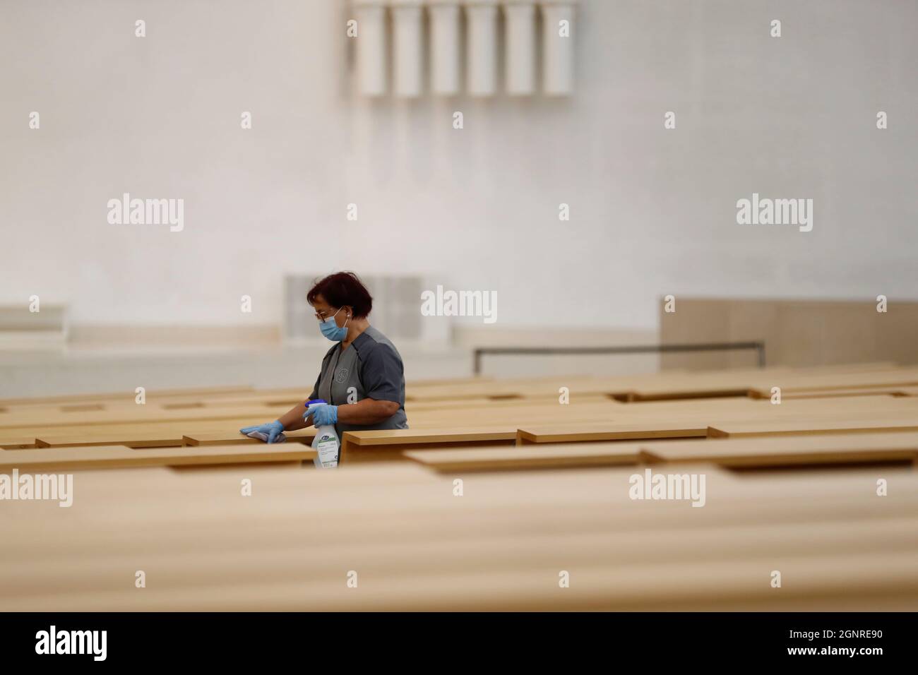 Basilica of the Holy Trinity. Covid-19 pandemic. Woman cleaning the ...