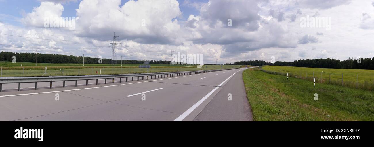 highway road in the countryside, roadside and asphalt, green forest and blue sky on a sunny day ...