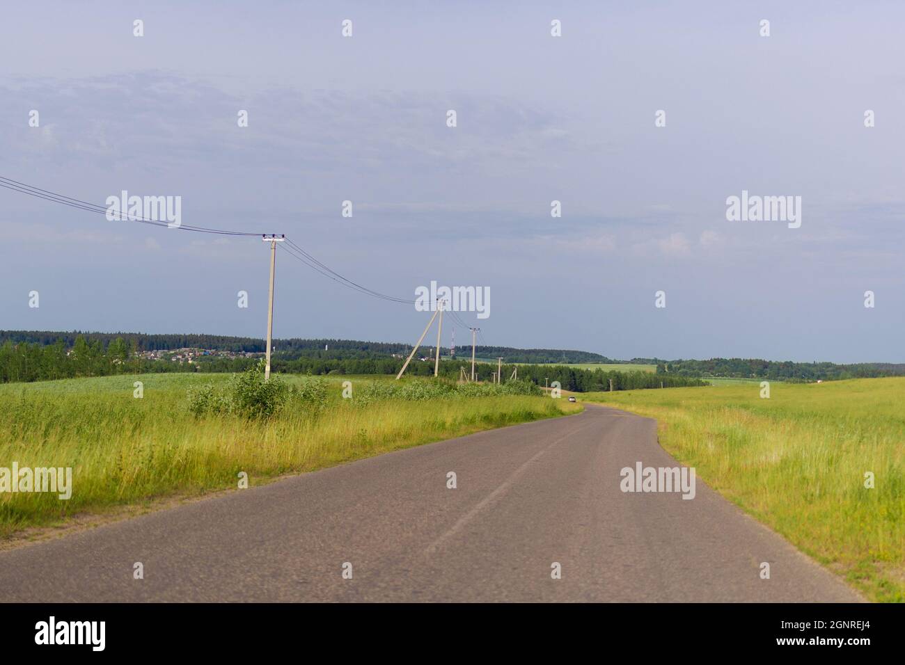 highway road in the countryside, roadside and asphalt, green forest and blue sky on a sunny day ...