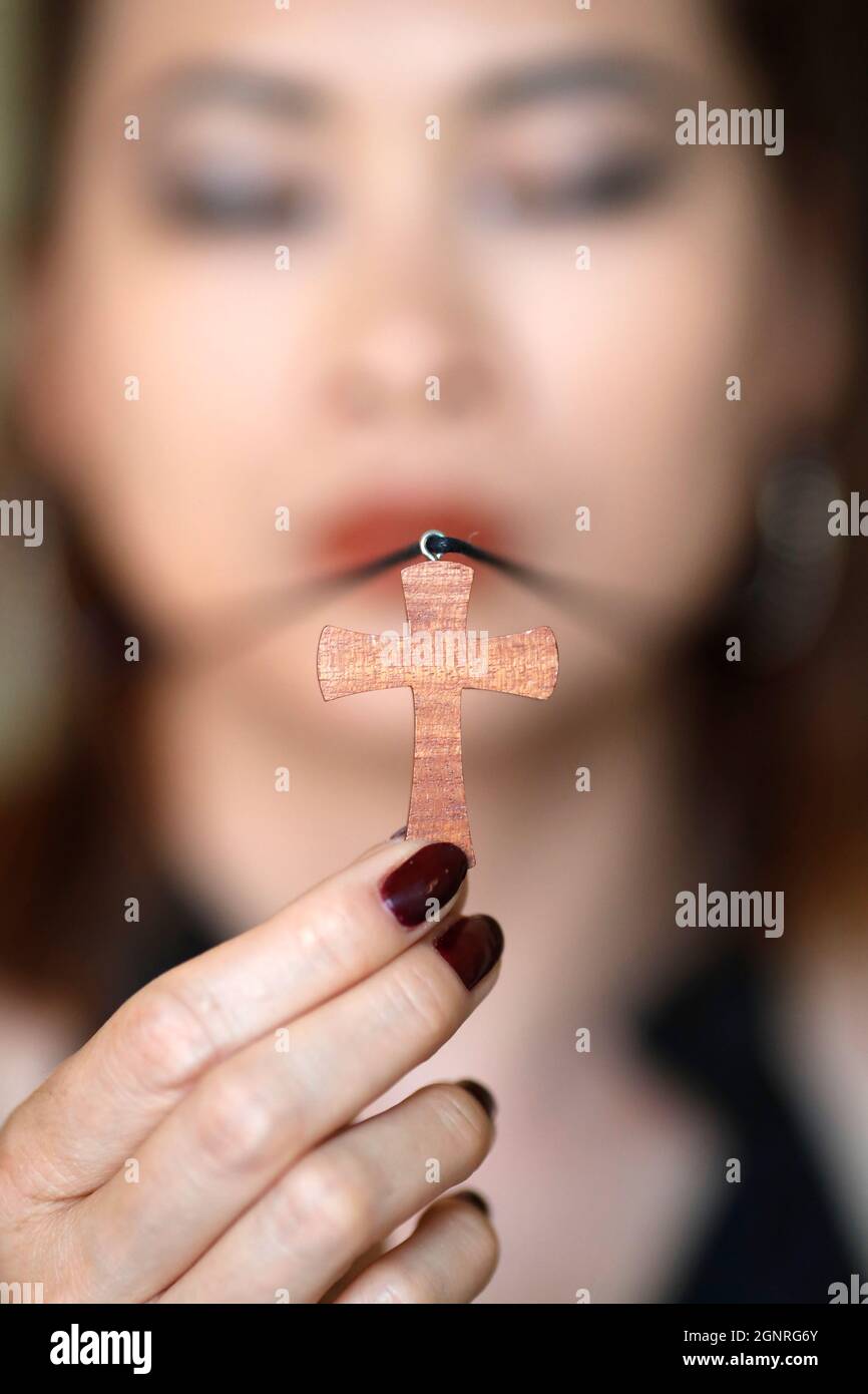 Christian woman wearing woodene cross pendant necklace Stock Photo - Alamy