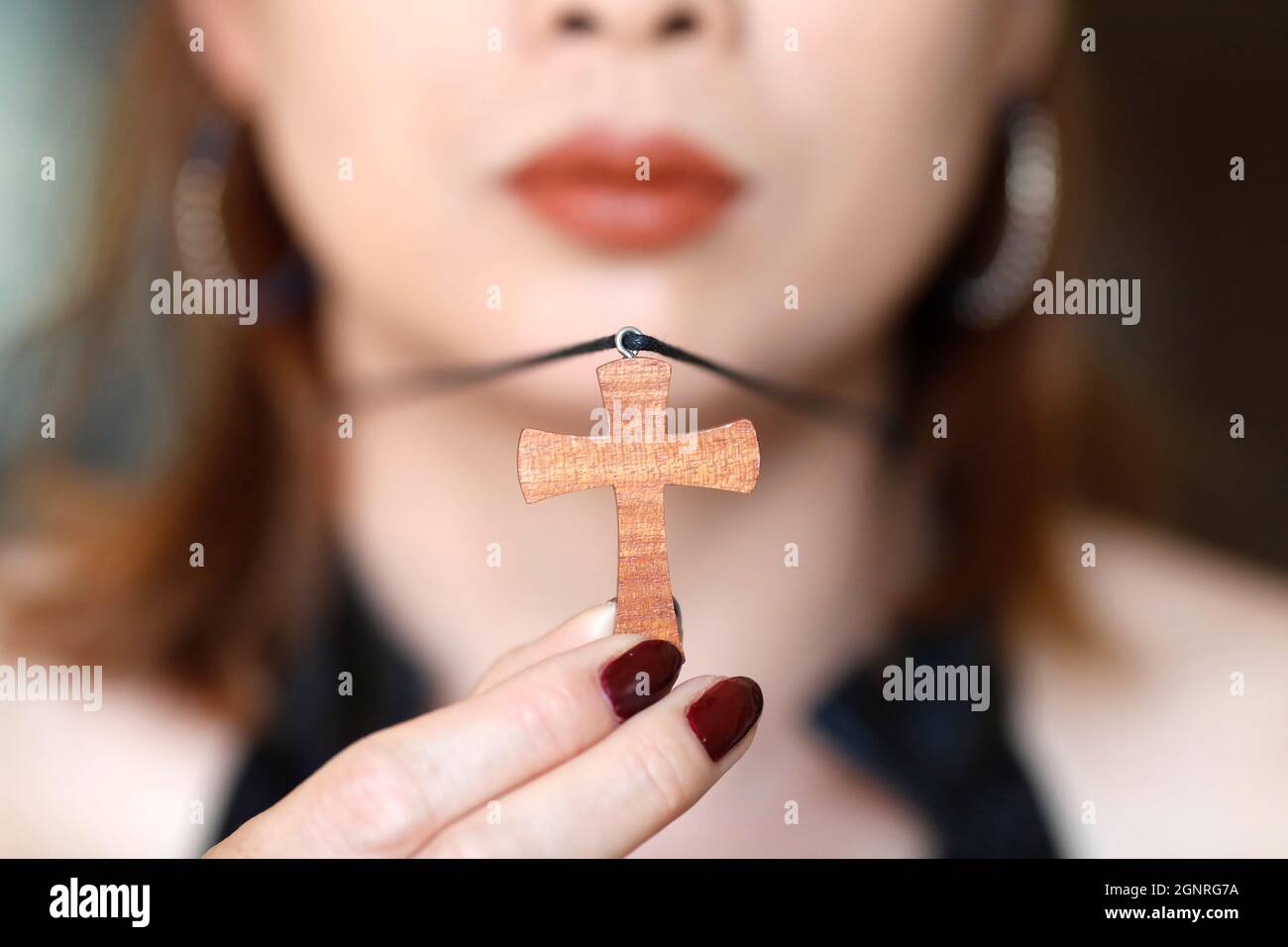 Christian woman wearing woodene cross pendant necklace Stock Photo - Alamy