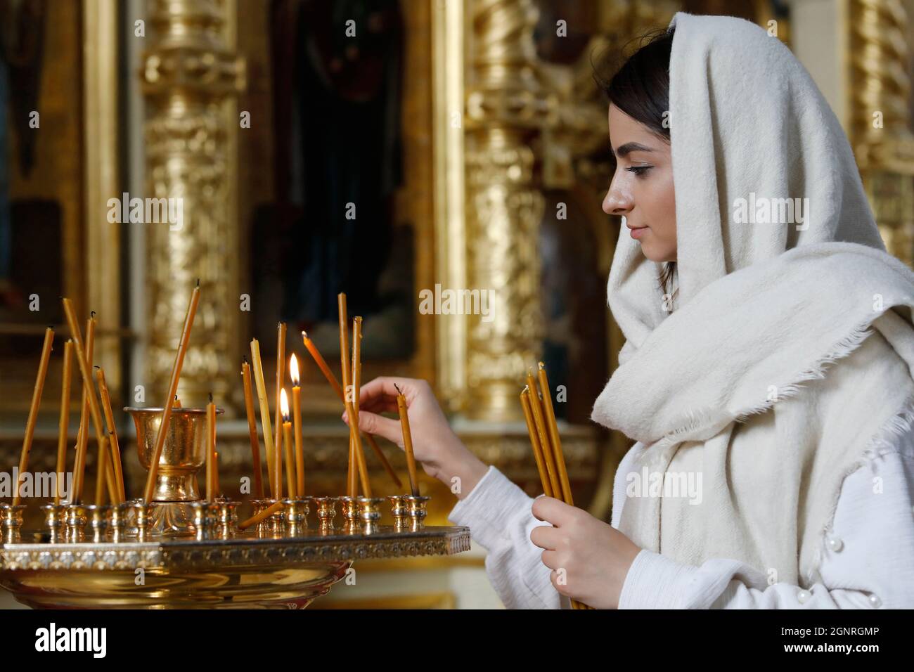 Capriana monastery church, Moldova. Young woman lighting a candle Stock ...