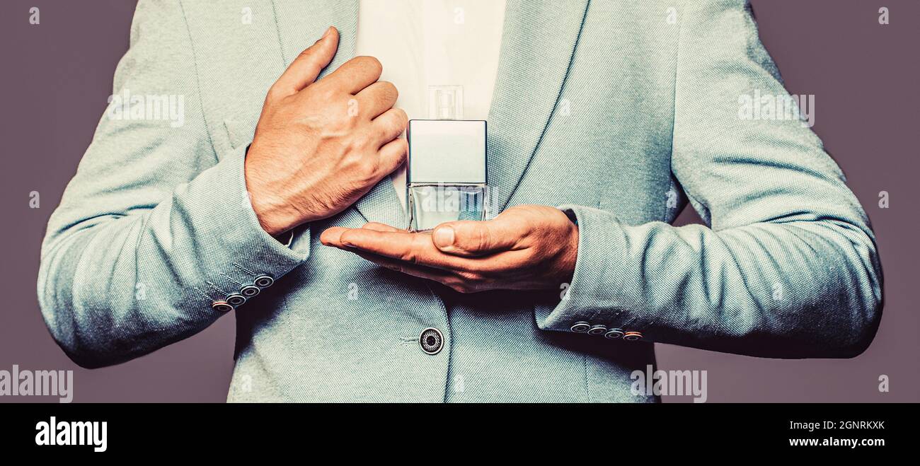 Men perfume in the hand on suit background. Man in formal suit, bottle ...