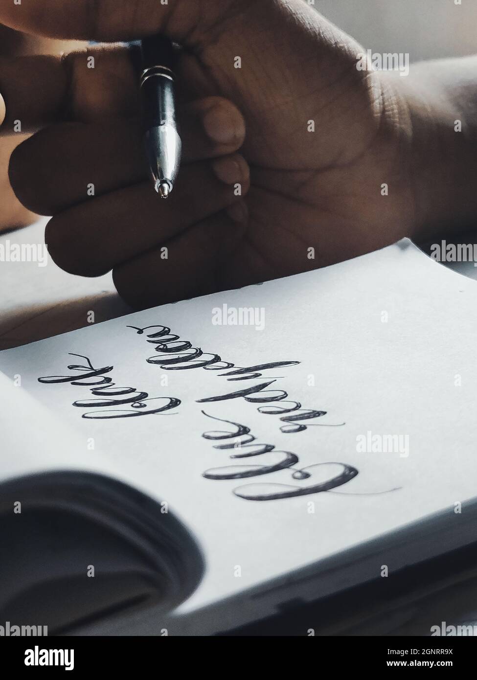 calligraphy notes on a white paper of a book Stock Photo - Alamy