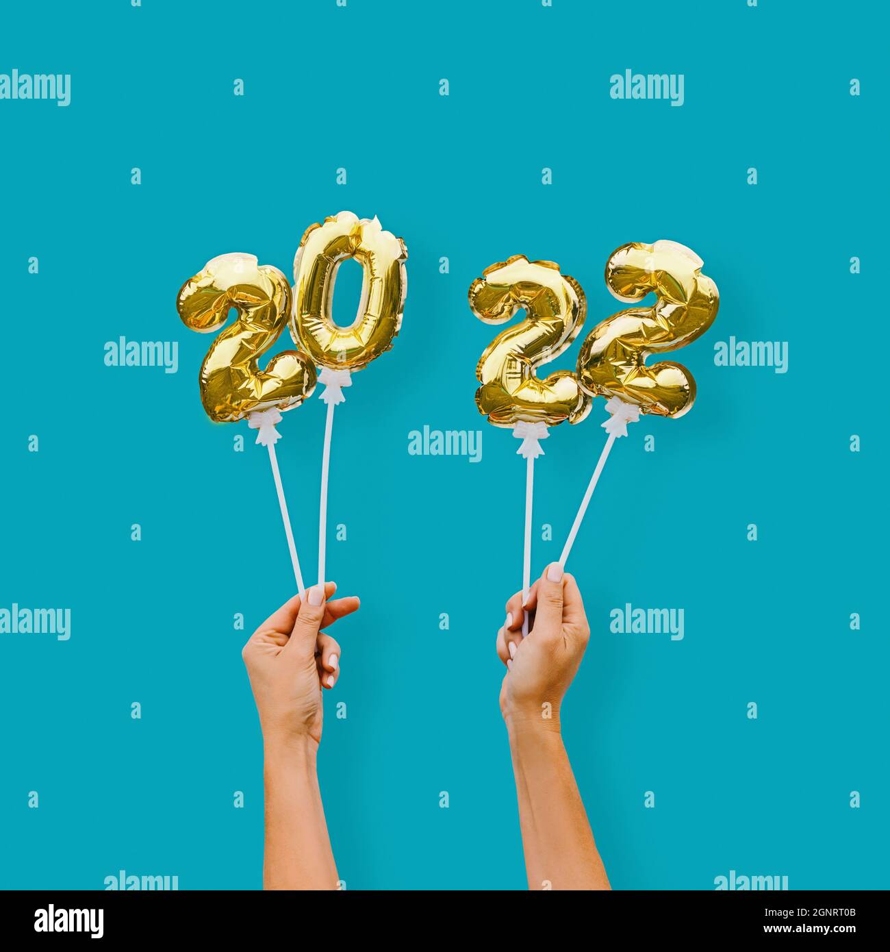 New year number 2022 made of golden balloons on a stick in female hands ...