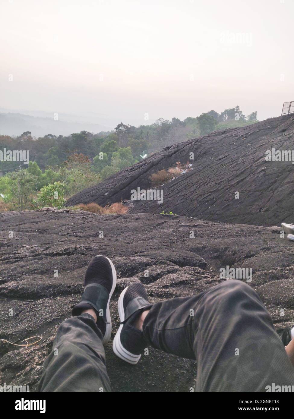 view point on top of a black rock hill with greenery Stock Photo - Alamy