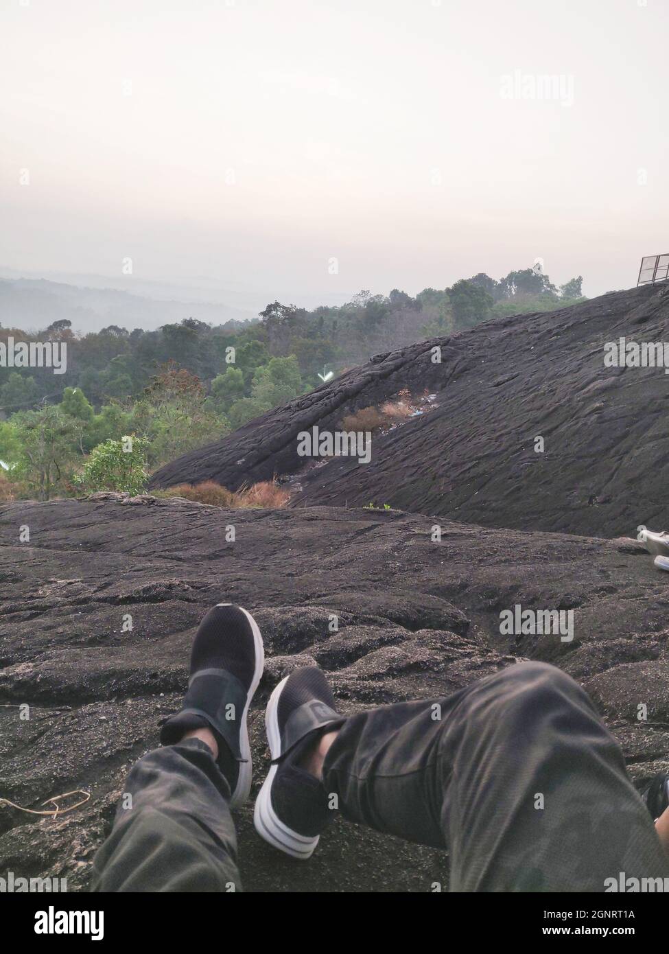 view point on top of a black rock hill with sunrise and greenery Stock ...