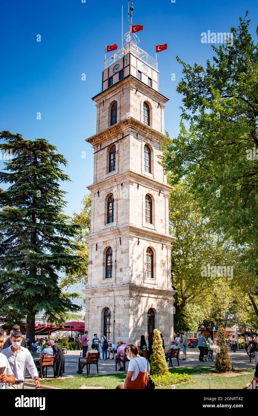 BURSA, TURKEY. AUGUST 15, 2021. Old tower on the square. People walking ...