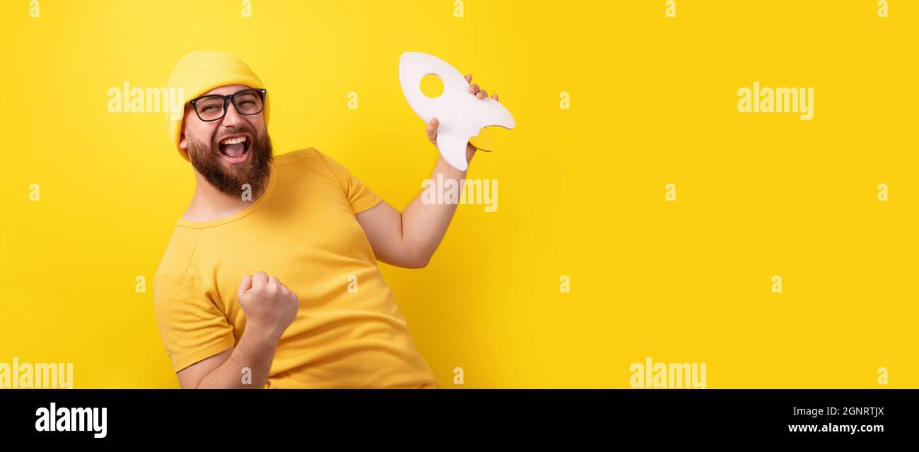 guy with rocket over yellow background, man with successful startup ...