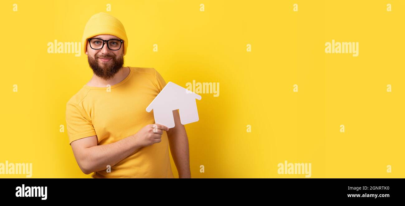 mortgage loan concept, guy holding house over yellow background ...